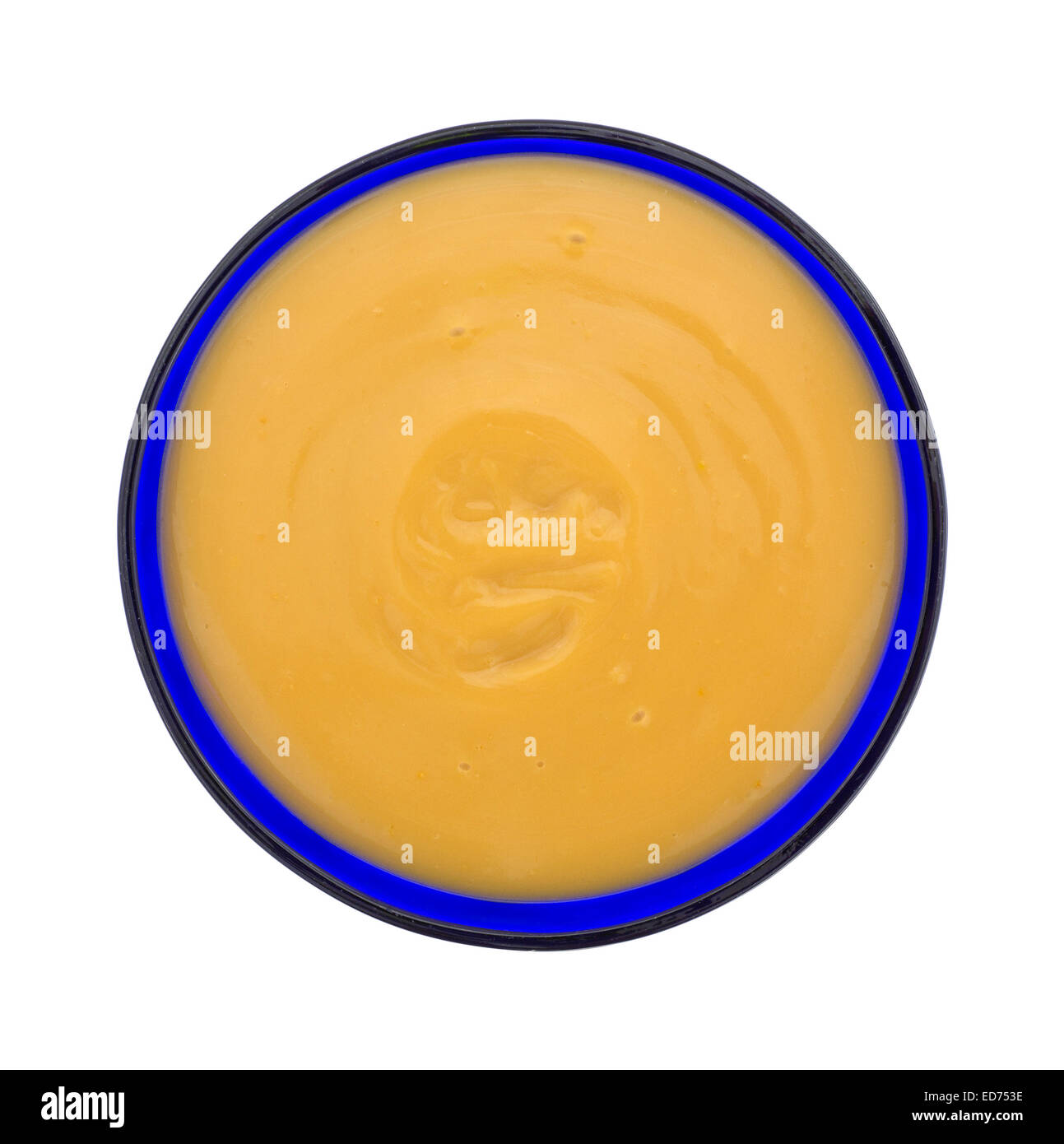 Top view of homemade butterscotch pudding in a bright blue bowl atop a ...