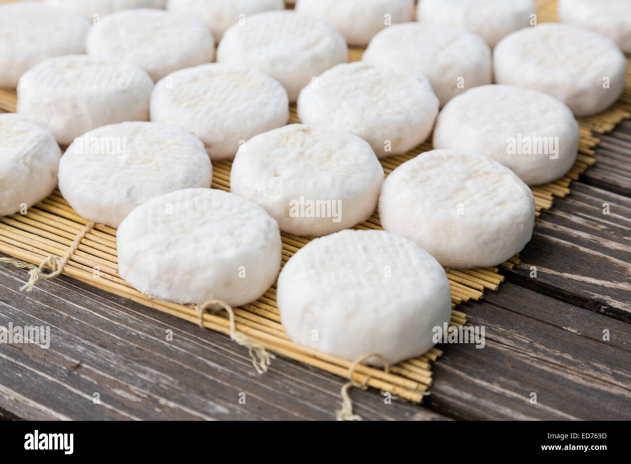 Set of small heads of young goat cheese crottin lying on wooden boards ...