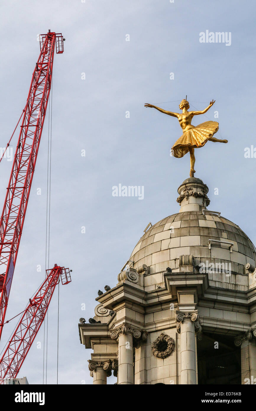 Cranes above the roof of the Victoria Palace theatre in London. The gilded statue of Anna ...