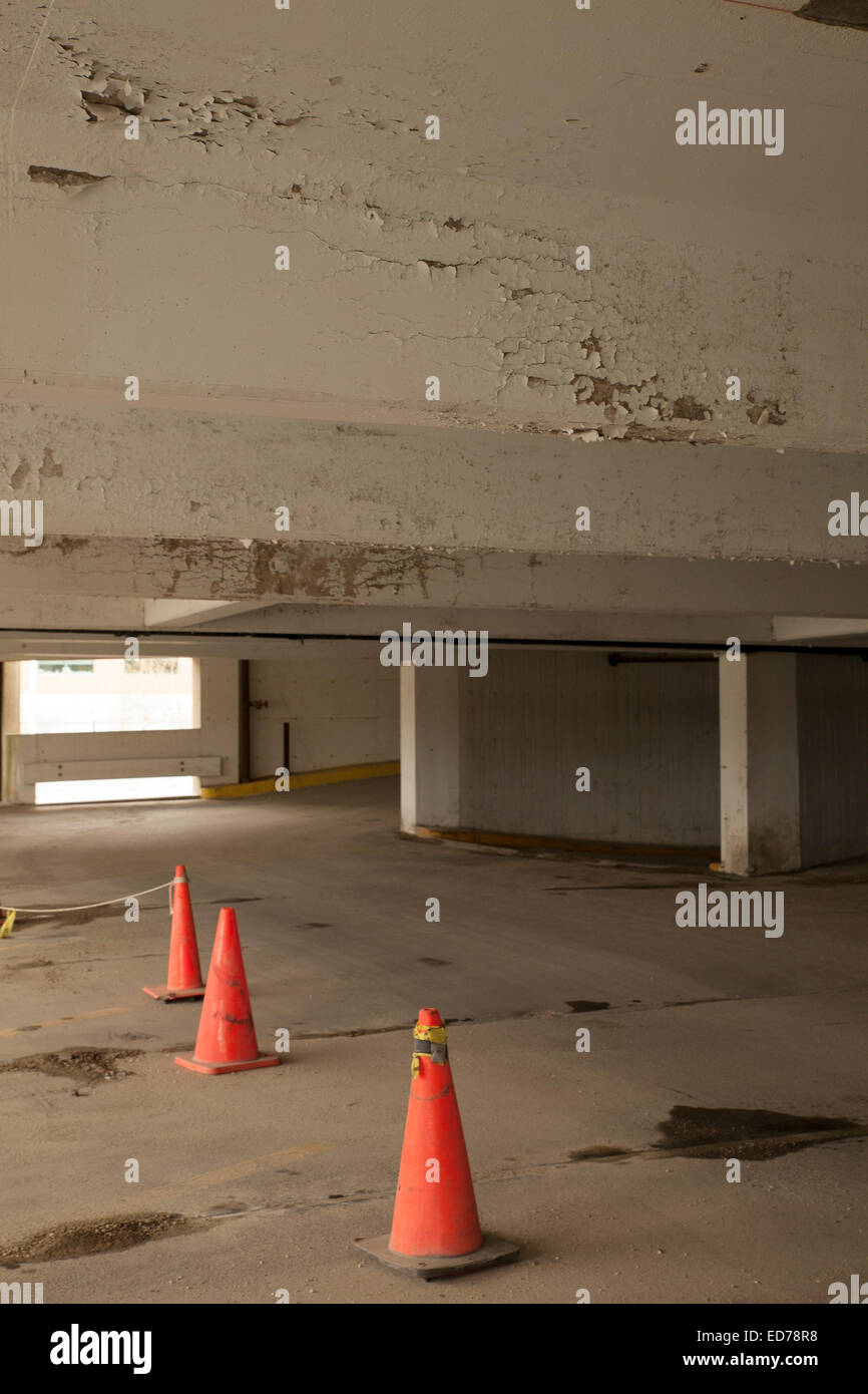 Orange traffic cones direct cars to a safer section of a parking garage ...
