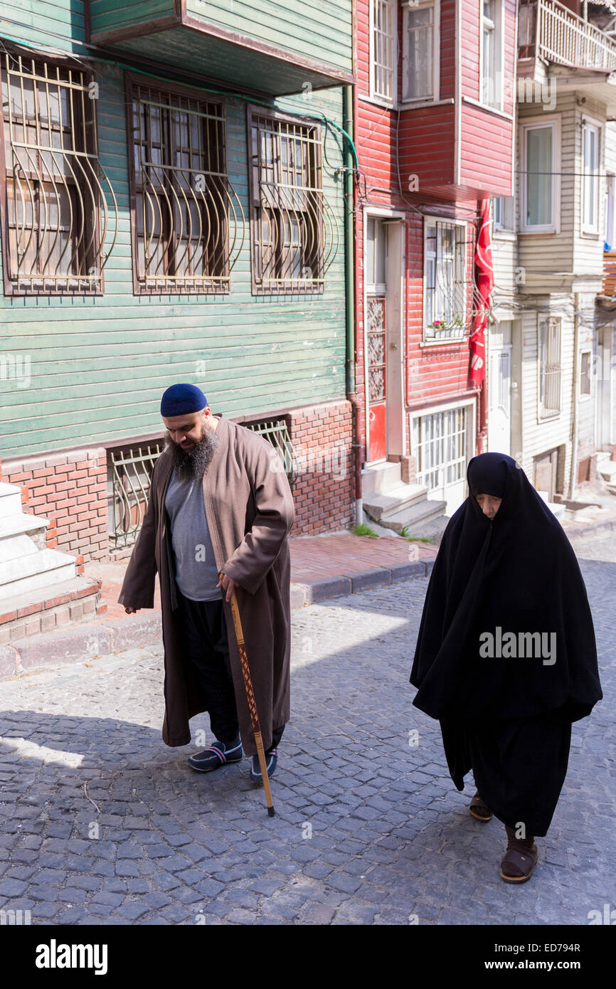 Muslim man wearing traditional clothing woman in niqab veil in area of ...