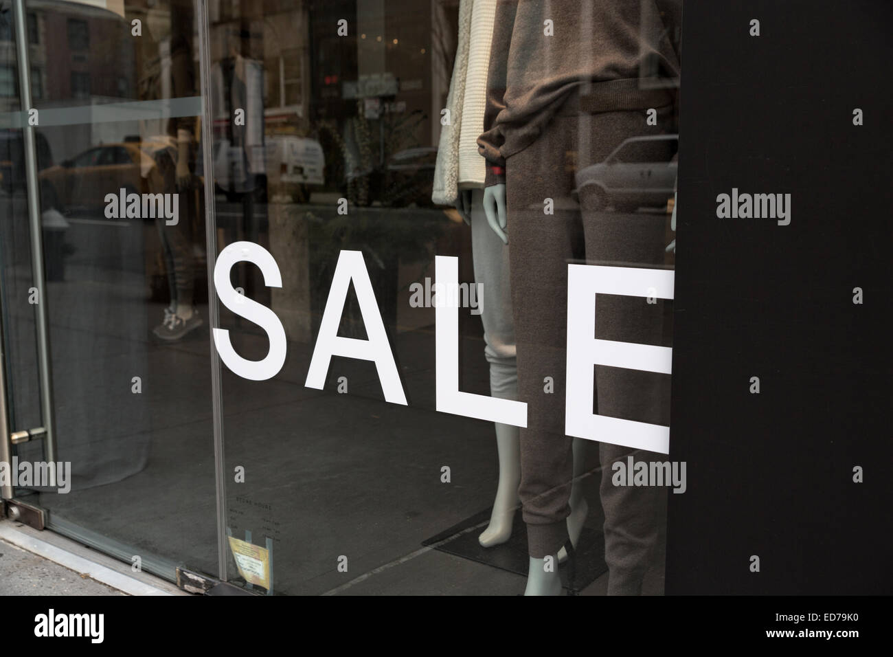 "Sale" Sign painted on a glass display window of an upscale retail ...