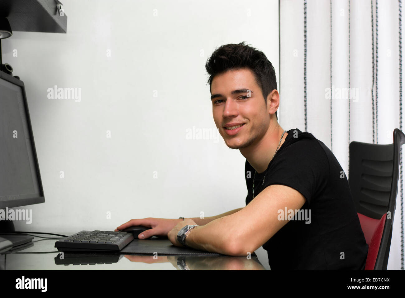 Handsome young man working or studyiing at computer Stock Photo - Alamy