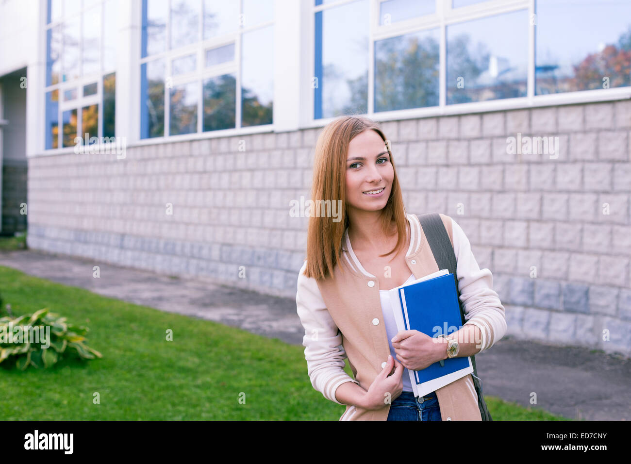 Student standing on building background with large windows Stock Photo ...