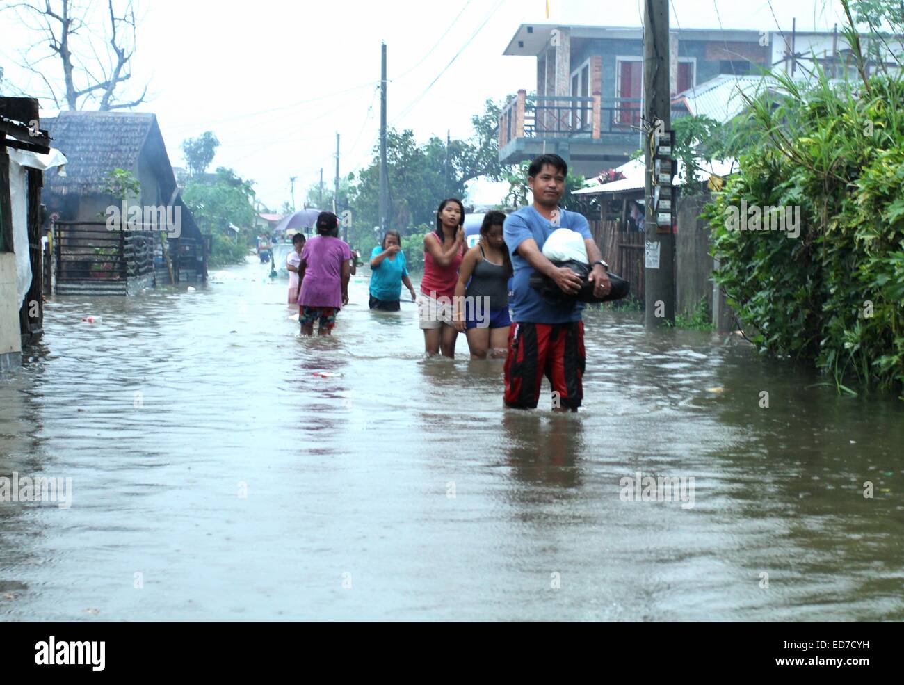 Mindanao, Philippines. 30th December, 2014. People walk through the ...