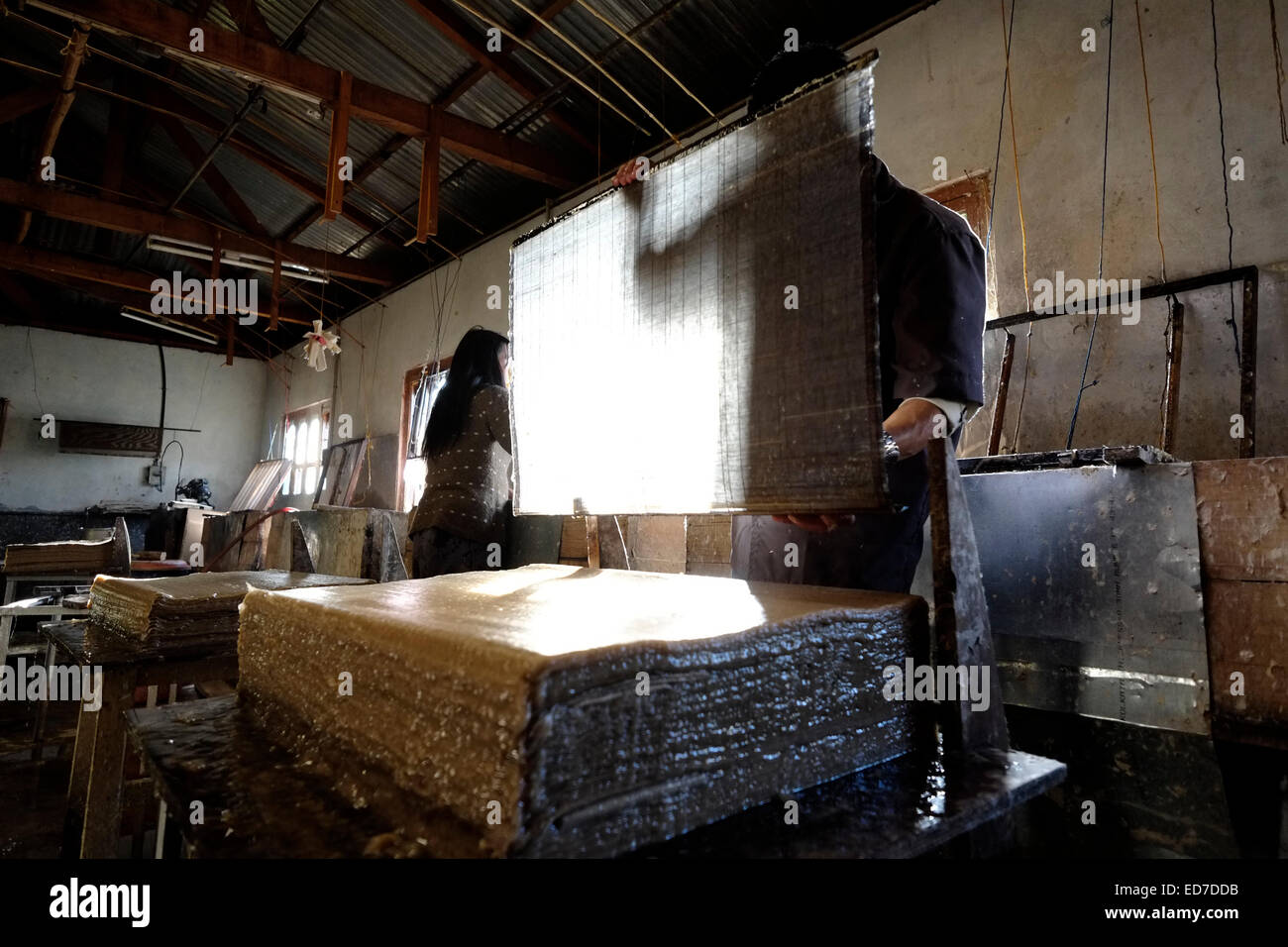 A worker prepares handmade paper at the Jungshi paper factory which ...