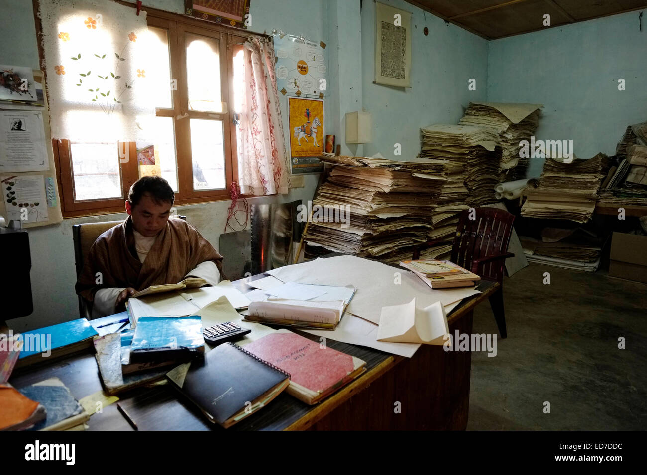 A worker sits amid piles of handmade papers at the office of Jungshi ...