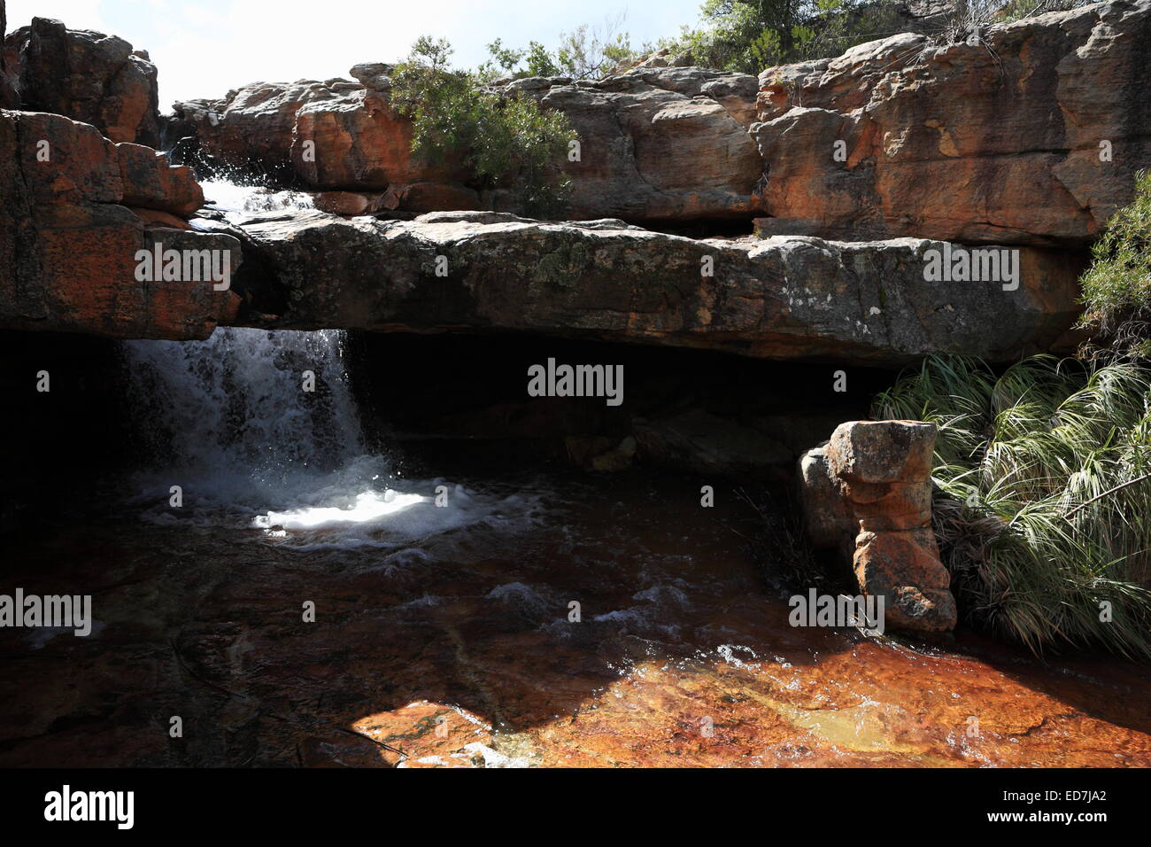River flowing through a hole in a rock overhang in the Gifberg mountain ...