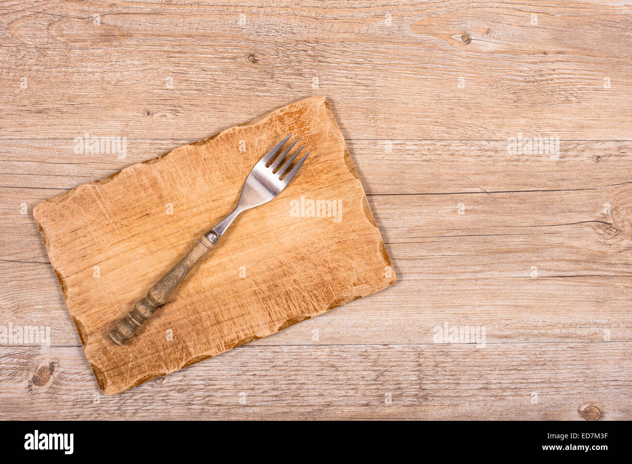 Fork on a rustic wooden board and table Stock Photo - Alamy
