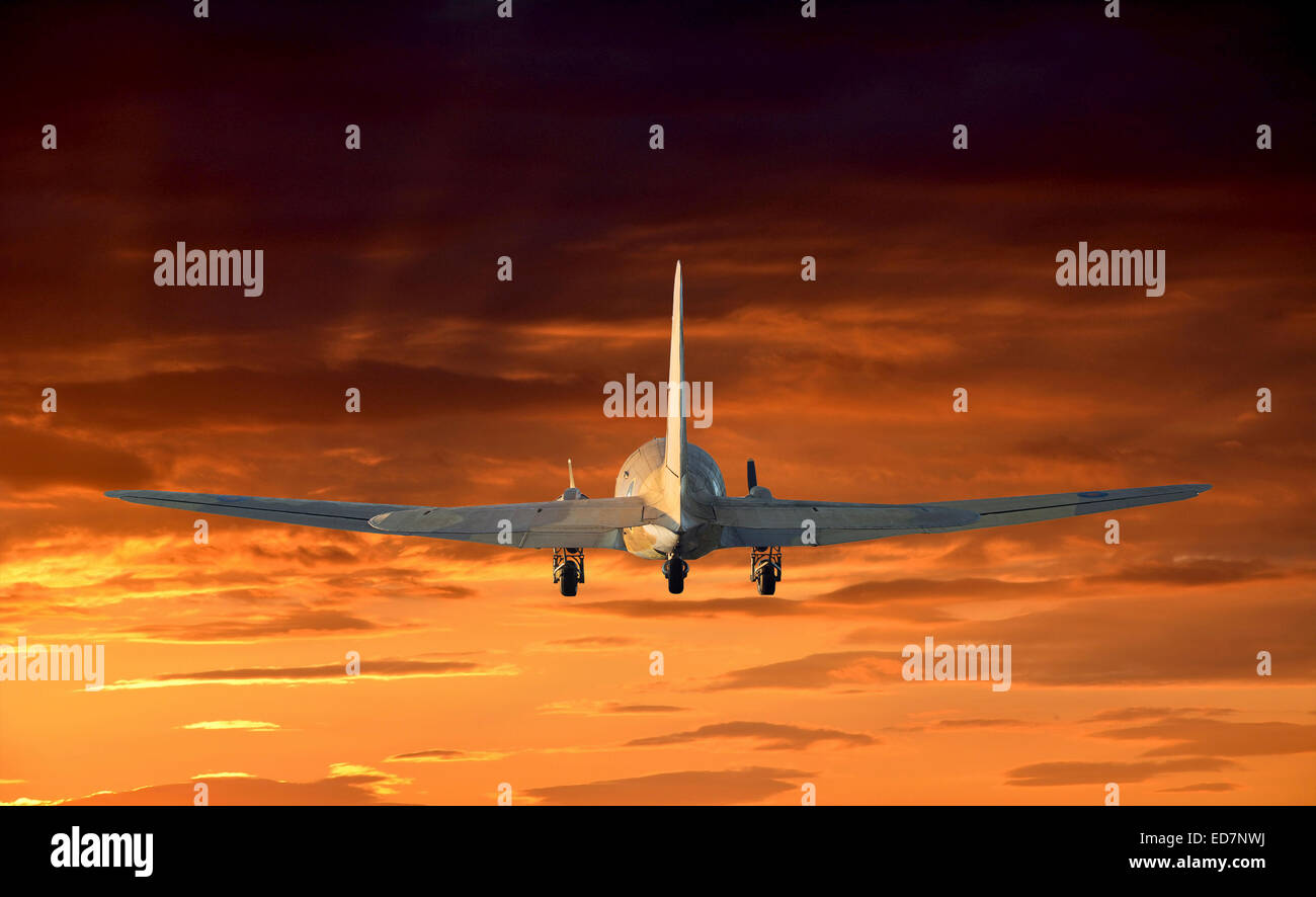 Flying old airplane with sunset background Stock Photo - Alamy