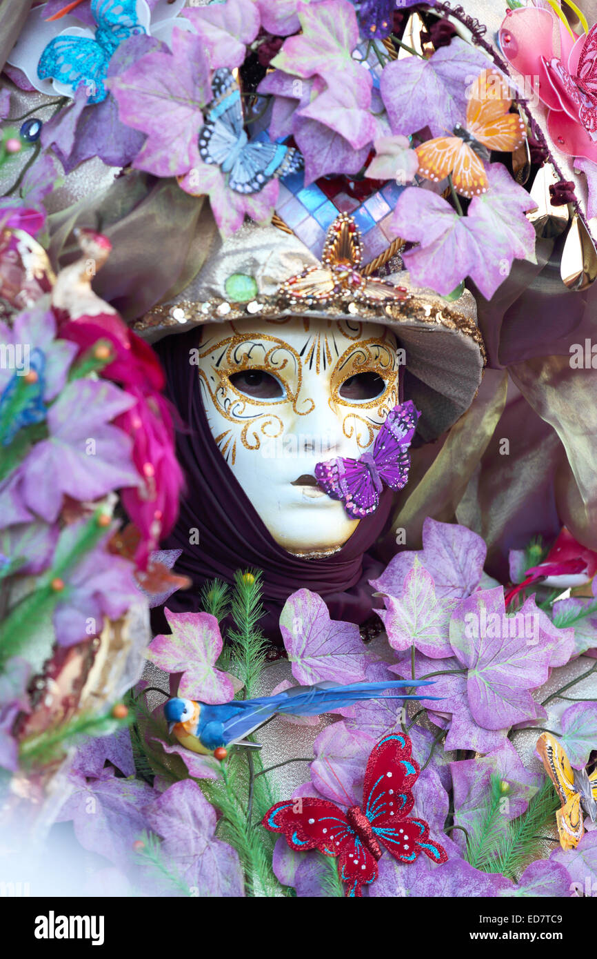 A pink and violet mask with floral decorations exhibited during the ...