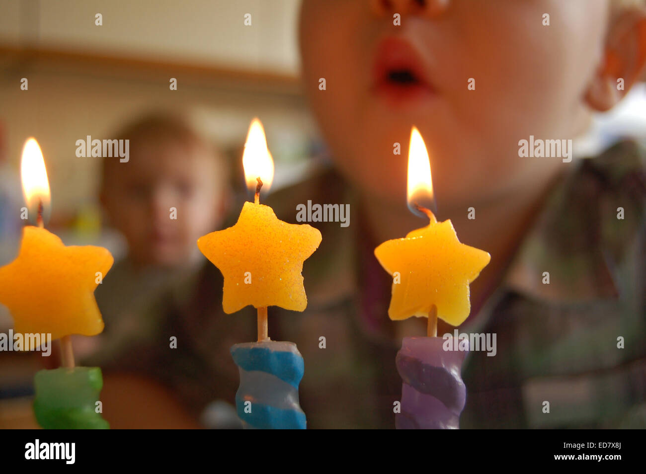 3 year old boy blowing out candles on birthday Stock Photo - Alamy