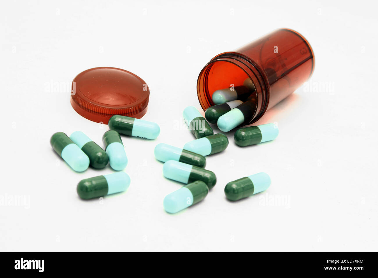 isolated capsules spilling out from small bottle Stock Photo - Alamy