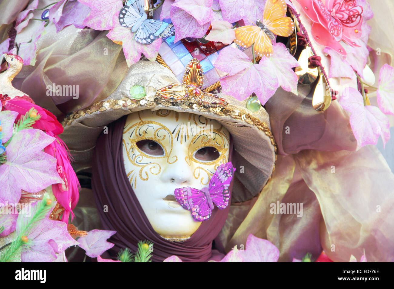 A pink and violet mask with floral decorations exhibited during the ...