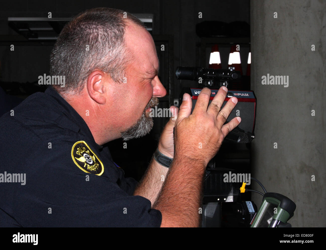 A traffic Police Officer using a laser Impulse surveying machine to ...