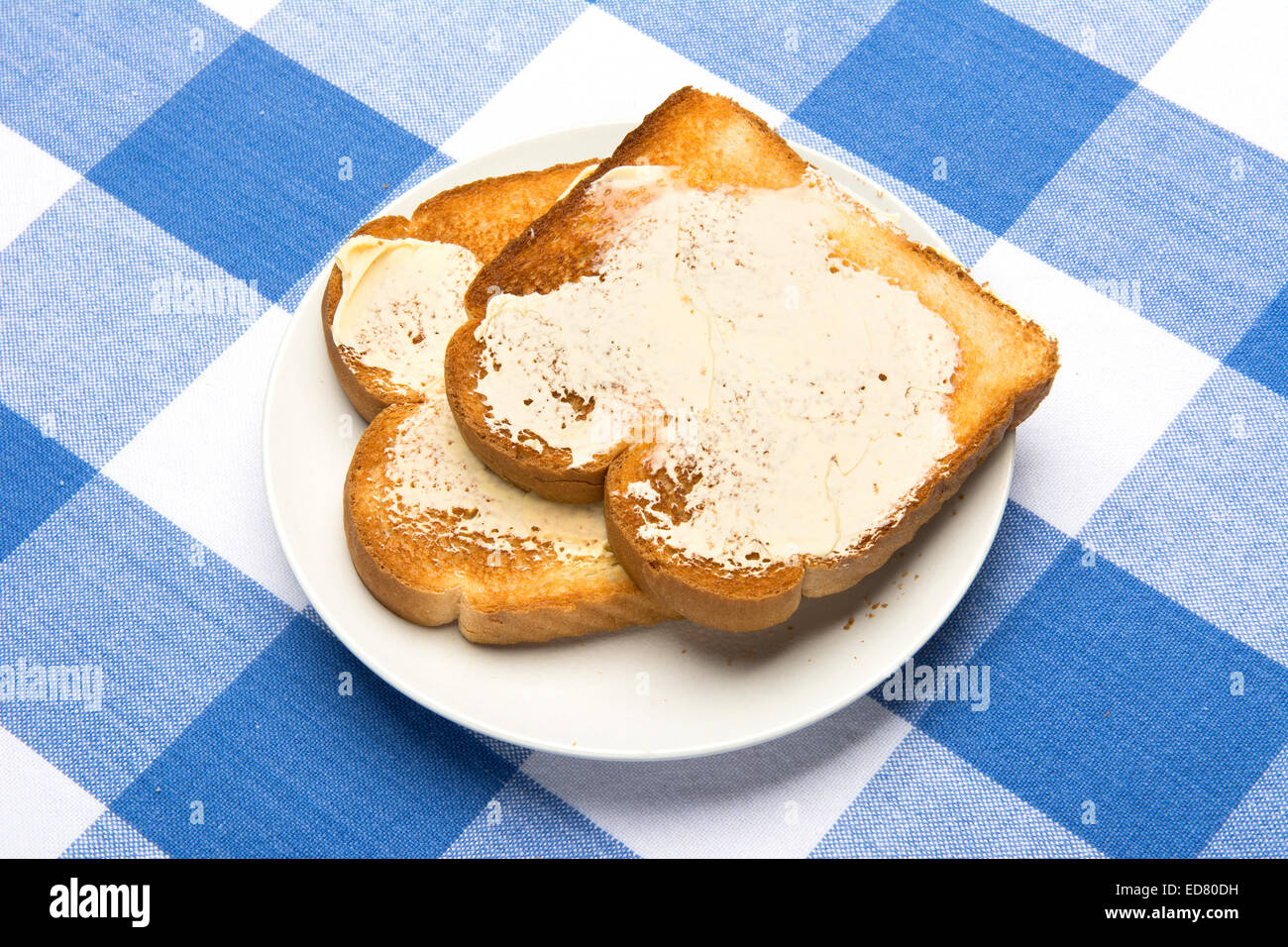 Fresh, hot toast spread with butter sits during mealtime to be consumed ...