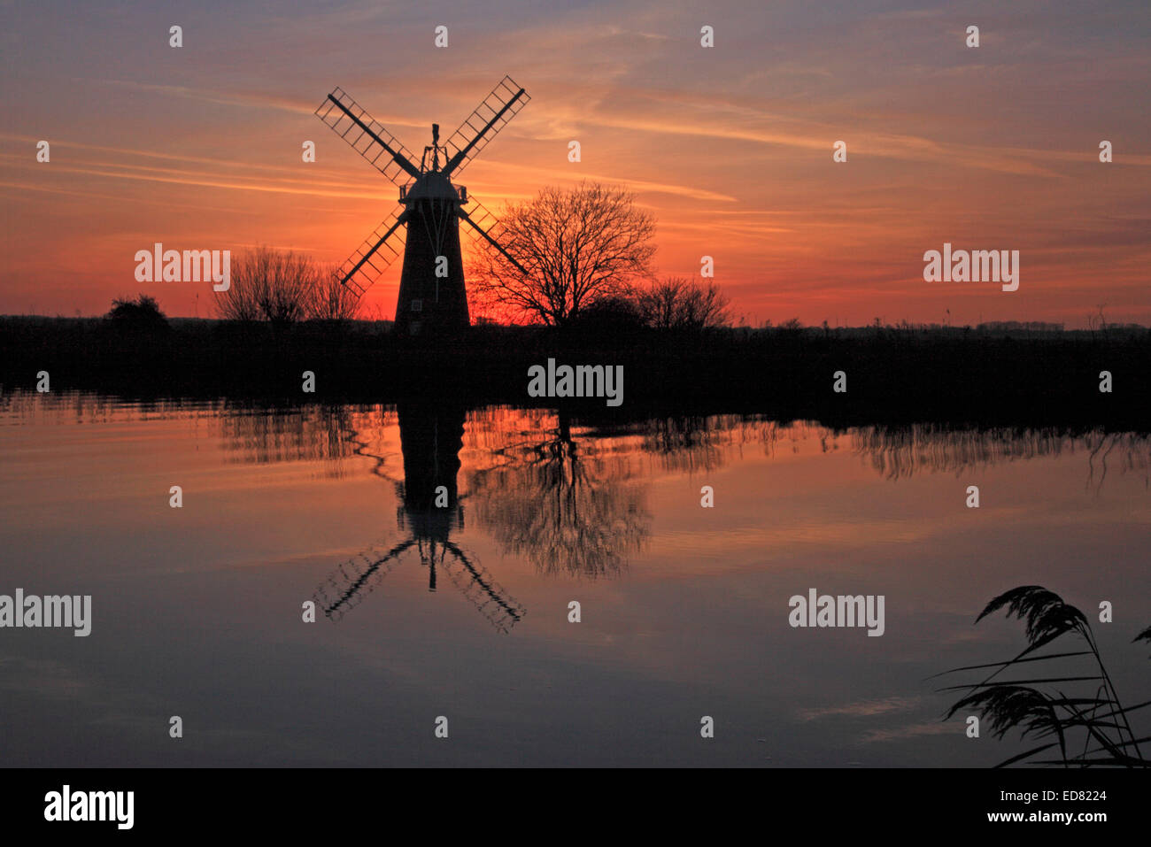 A sunset on the River Thurne with windmill on the Norfolk Broads at ...