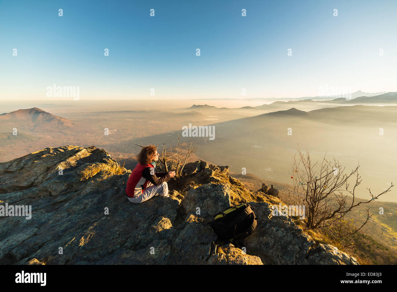 Female hiker reaching her goal at the mountain top and looking at ...