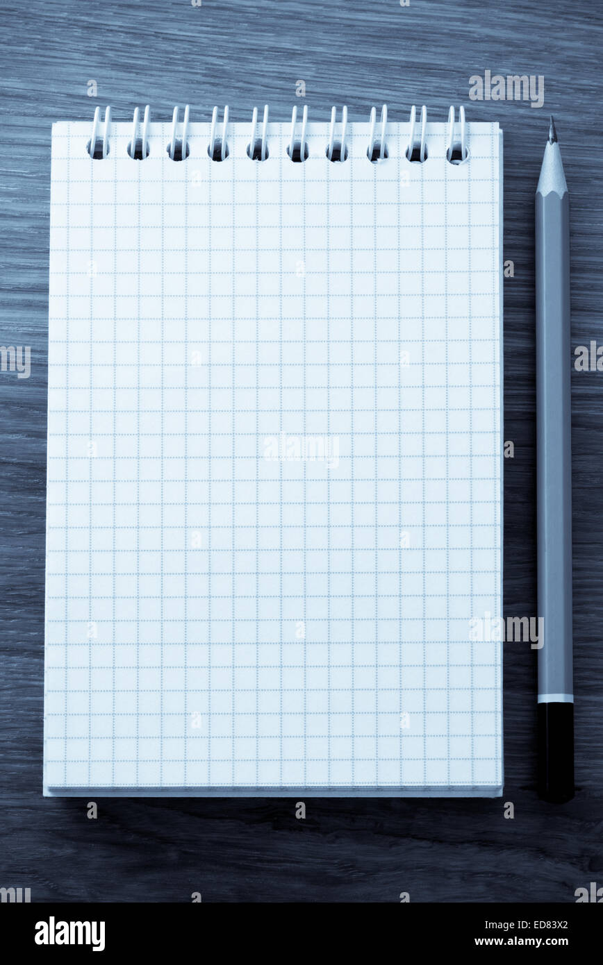 checked notebook on wood background Stock Photo - Alamy