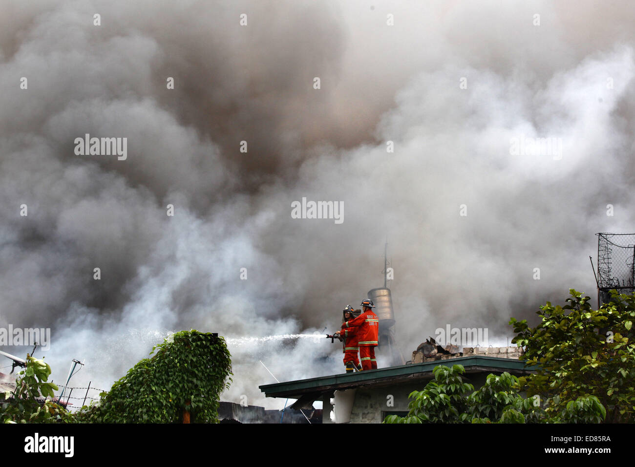 Quezon City, Philippines. 1st Jan, 2015. Firefighters try to put out a ...