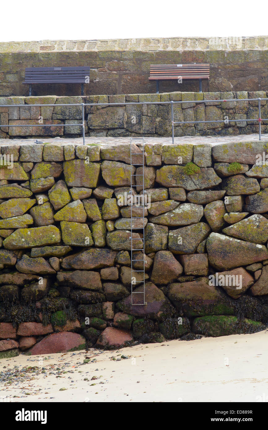 Mousehole harbour wall rocks colour stained by sea and plant life ...