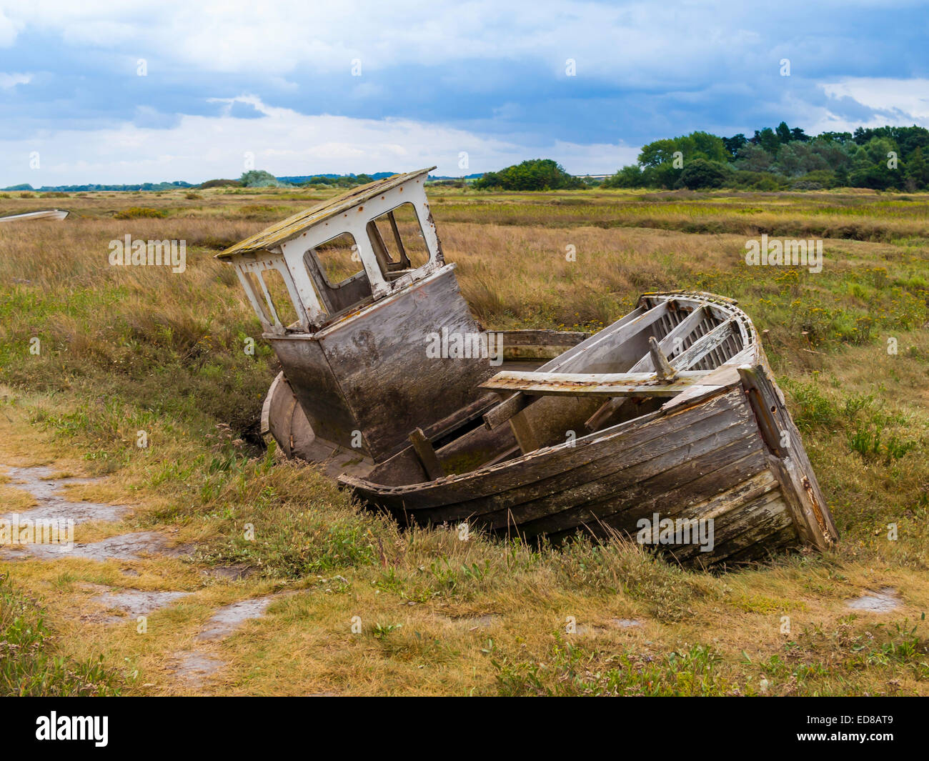 An old derelict decaying abandoned wooden boat on a salt marsh at ...