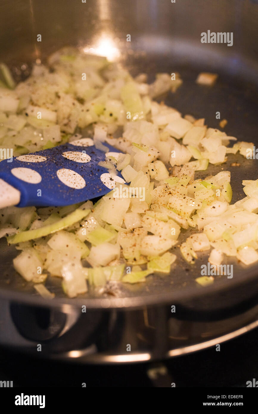 Cooking onions in a pan on the hob Stock Photo - Alamy