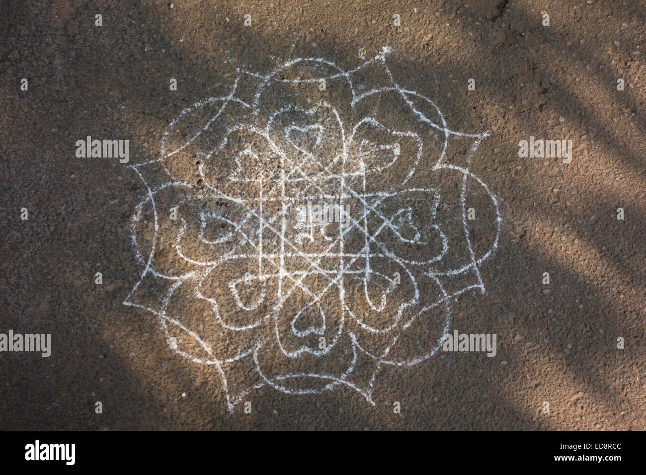 A chalk pattern on the pavement outside someone's house in Mysore as a ...