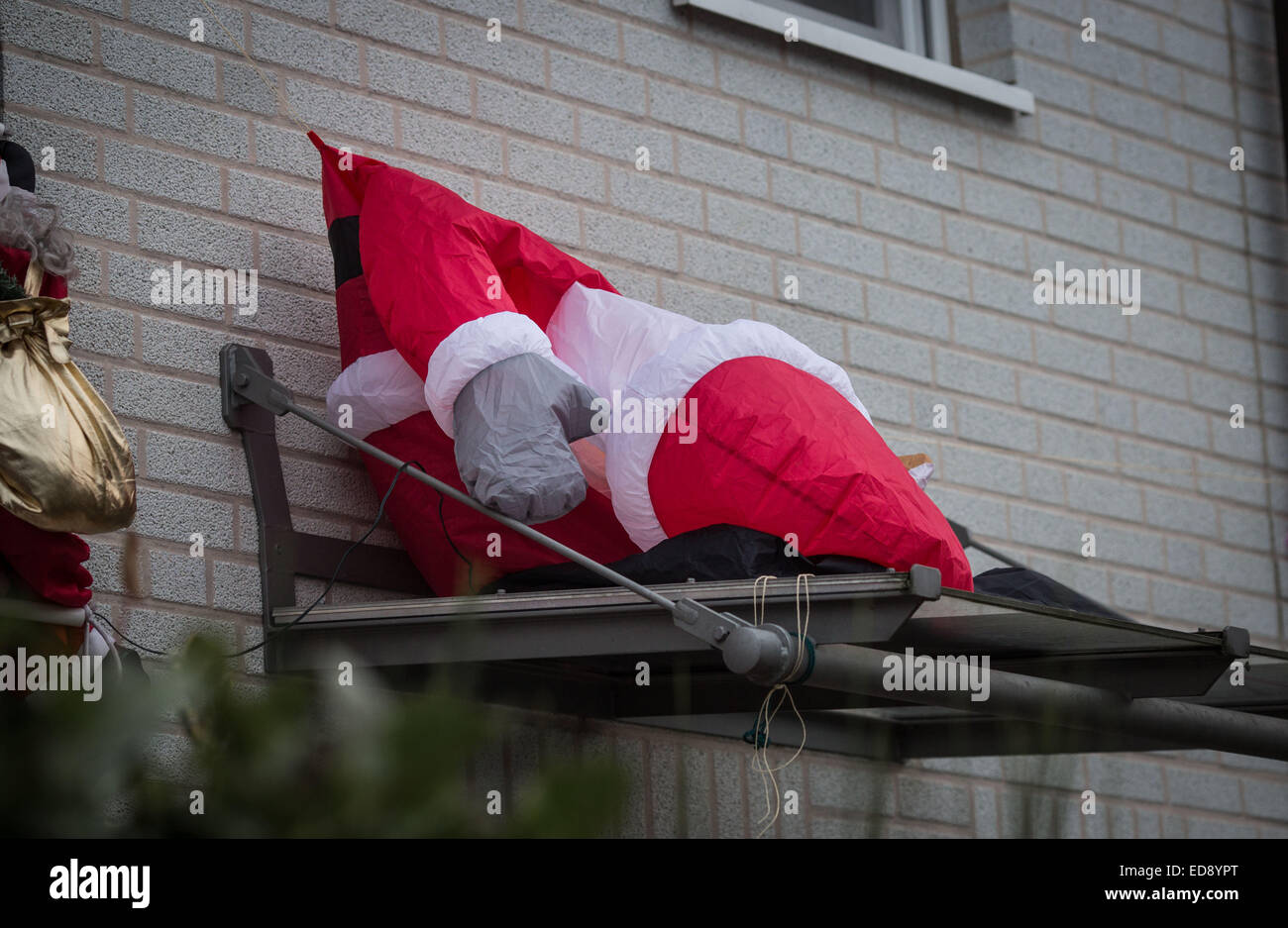 An inflatable Santa Claus figure hangs in his attachment ropes over an ...