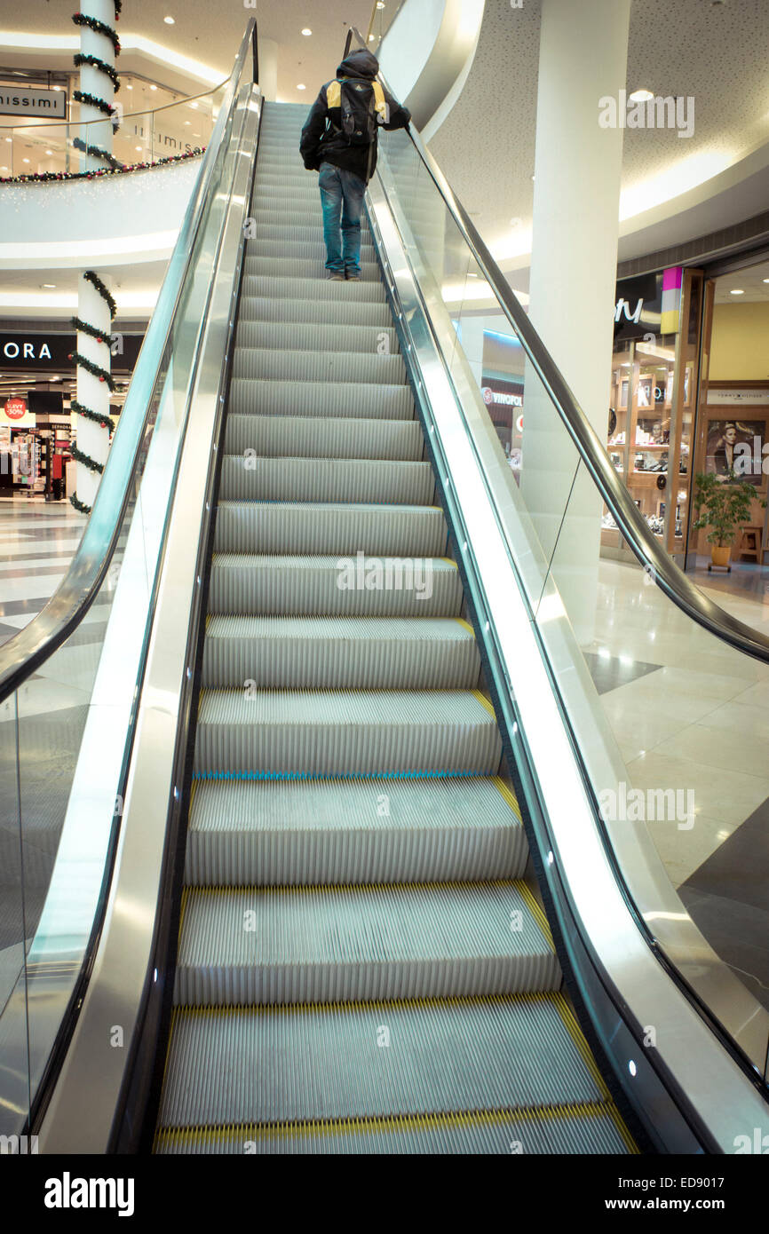 student boy on escalator in a commercial store, probably skipping class ...