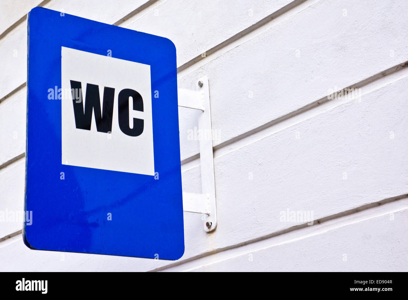 WC sign blue on white wall Stock Photo - Alamy