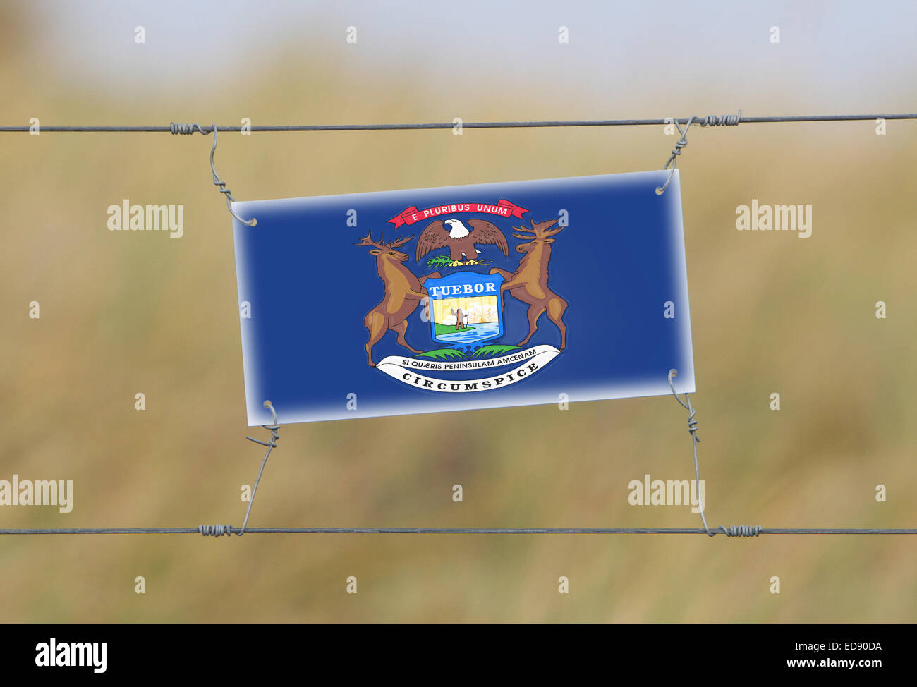 Border fence - Old plastic sign with a flag - Michigan Stock Photo - Alamy