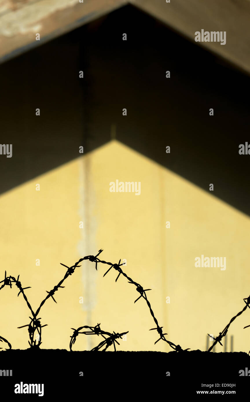 Barbed wire on outer wall of a suburban house Stock Photo - Alamy