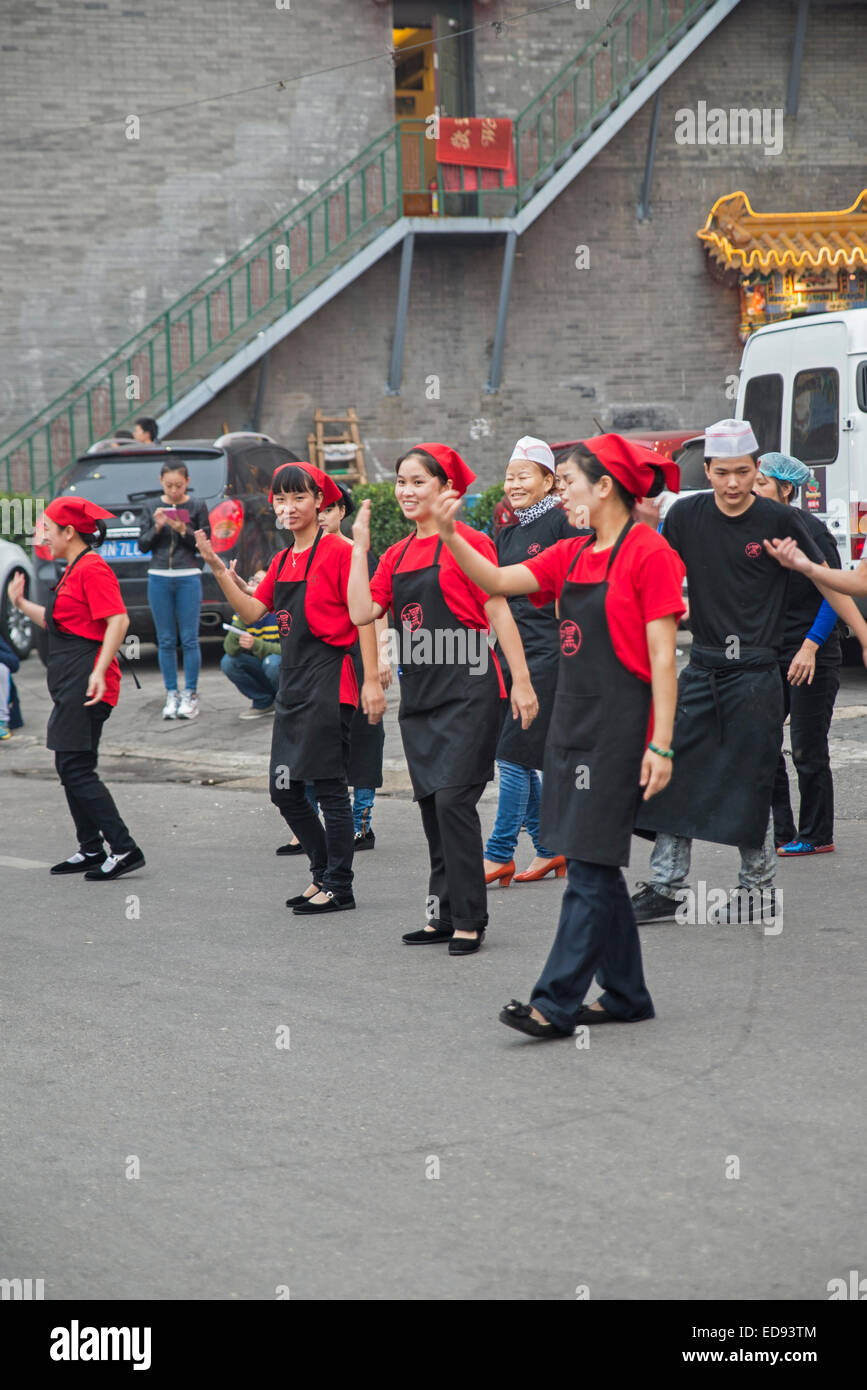 Employees dancing before work outside restaurant, Beijing, China Stock ...