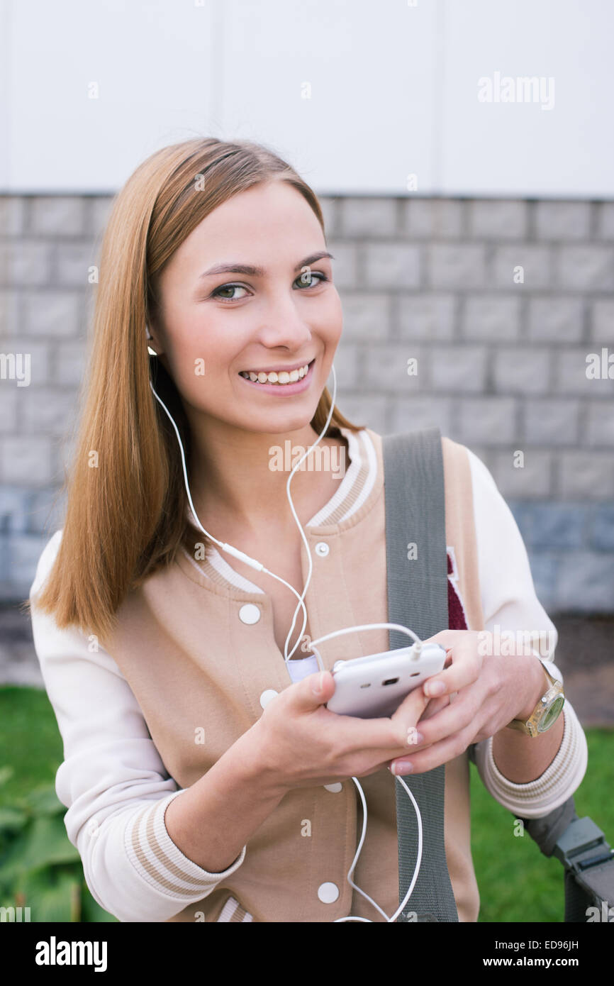 Student listening phone by headphones and smiling at camera Stock Photo ...