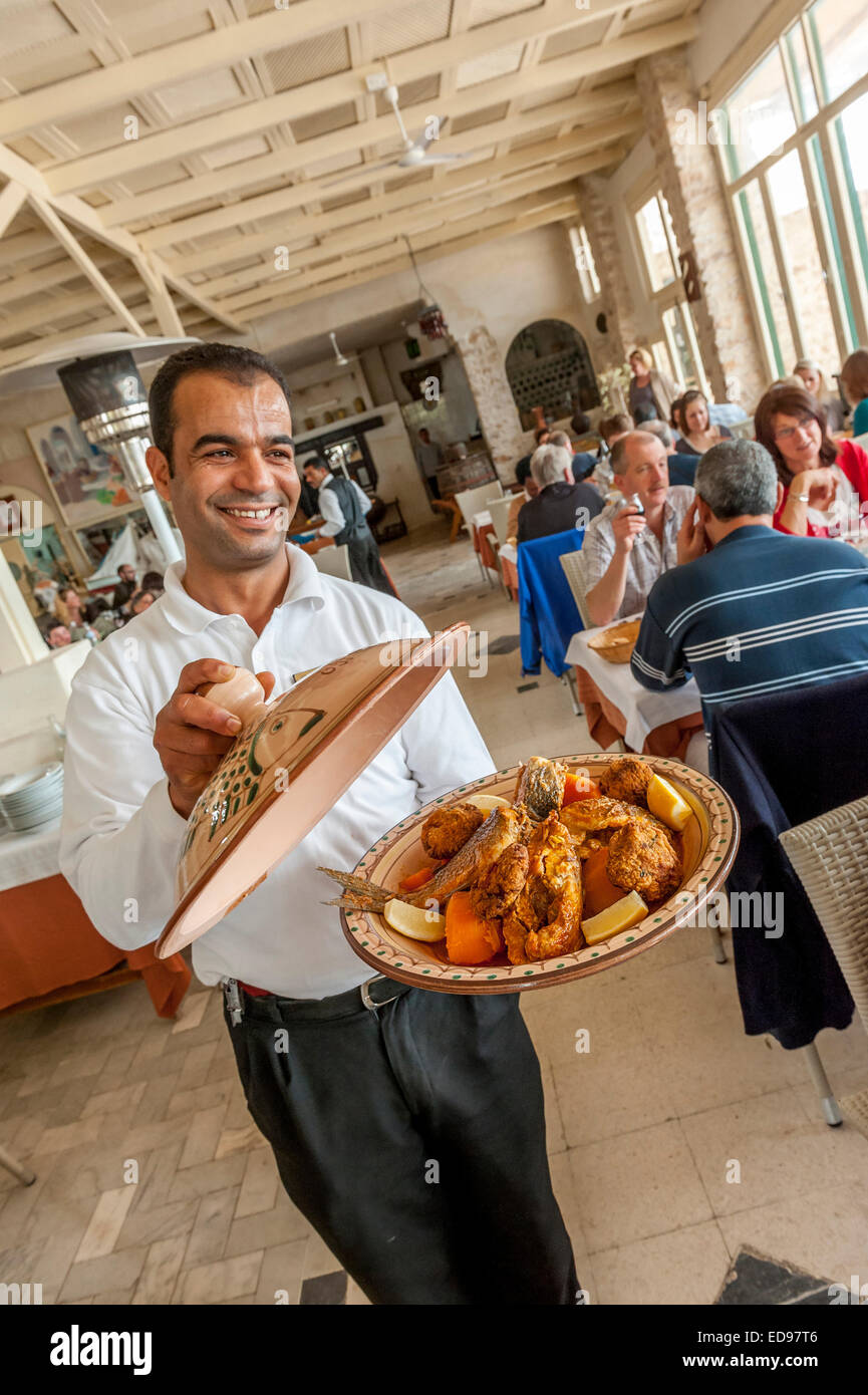 A waiter displays a typical seafood tajine dish served at Restaurant ...