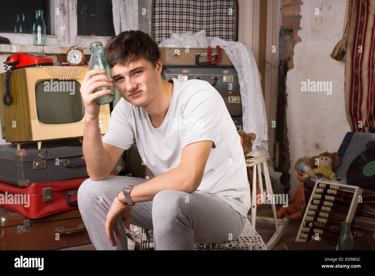 Sitting Drunk Young Man in Casual Clothing Holding Glass Bottle at the ...