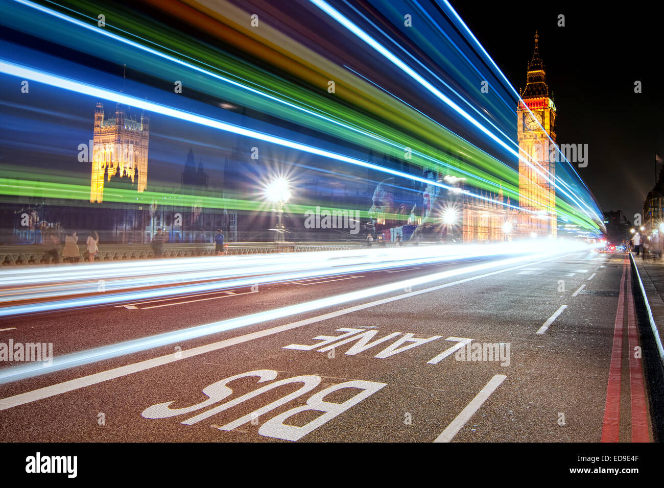 A London bus creates trails of light across the face of the Houses of ...