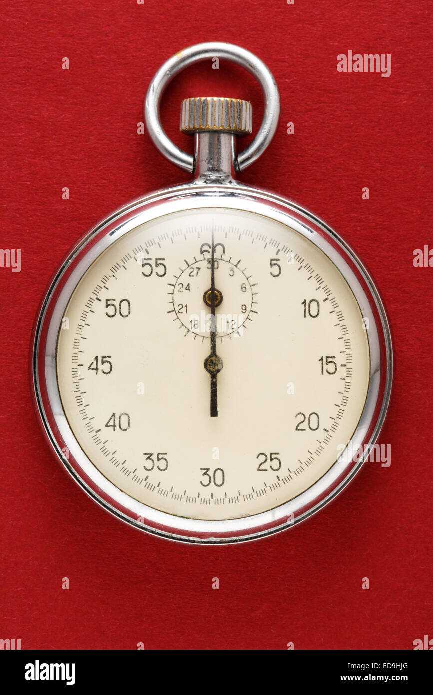 Single stopwatch closeup on red paper background Stock Photo - Alamy