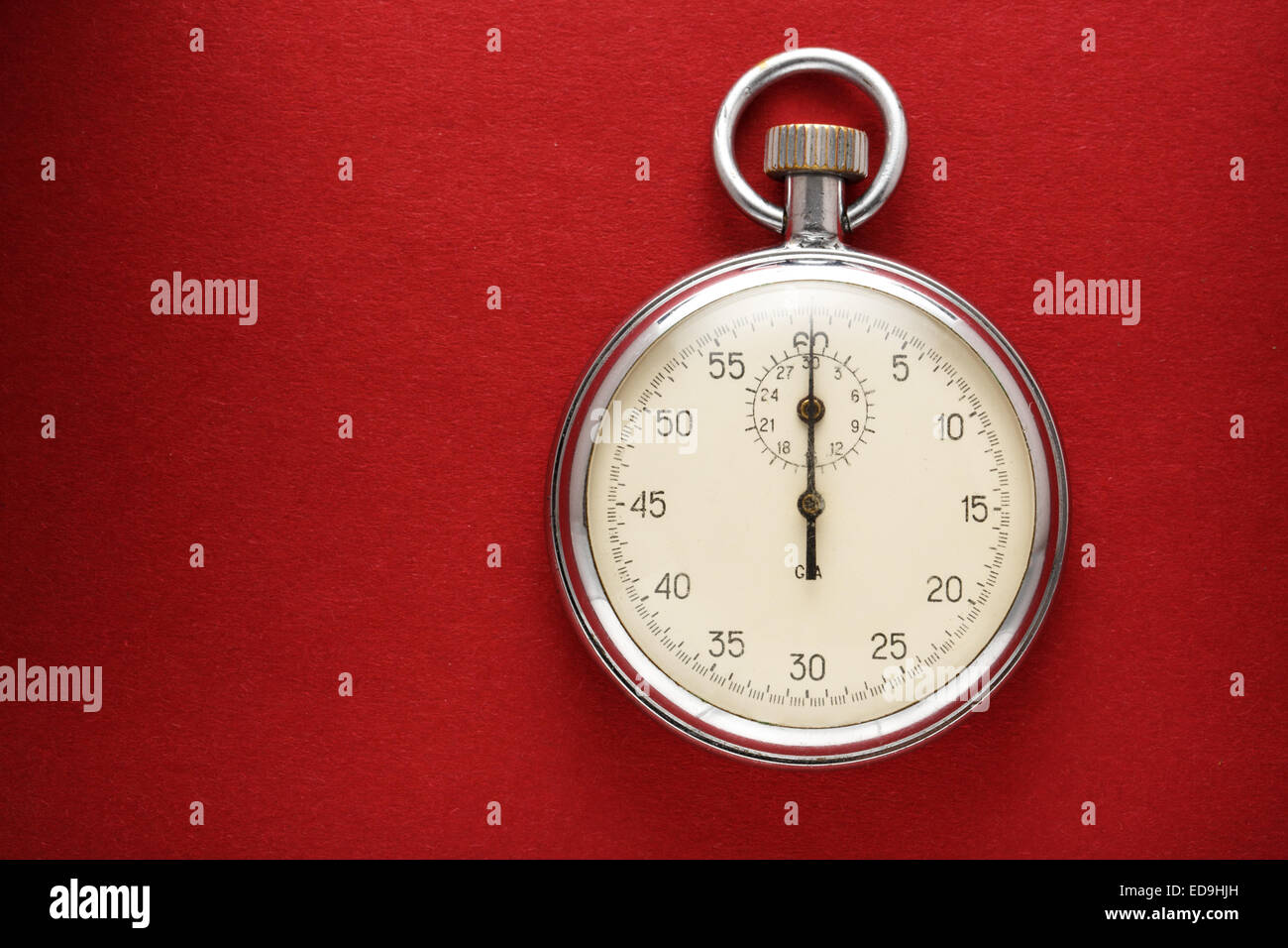 Single stopwatch closeup on red paper background Stock Photo - Alamy