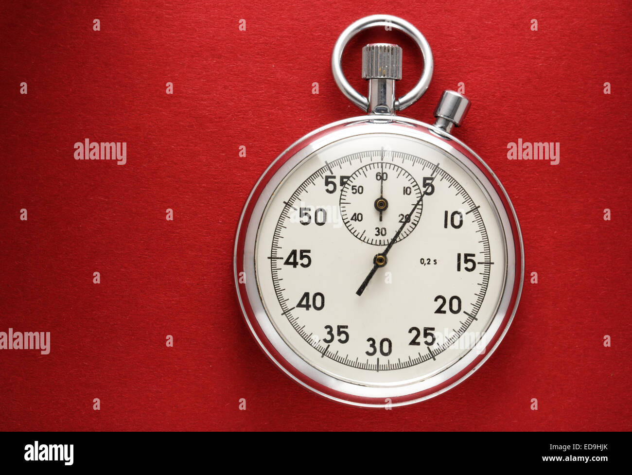 Single stopwatch closeup on red paper background Stock Photo - Alamy
