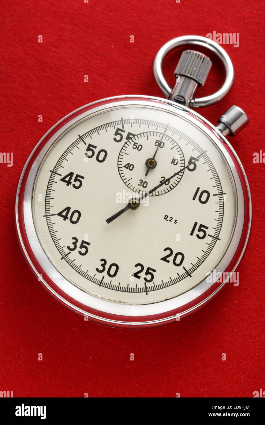Single stopwatch closeup on red paper background Stock Photo - Alamy