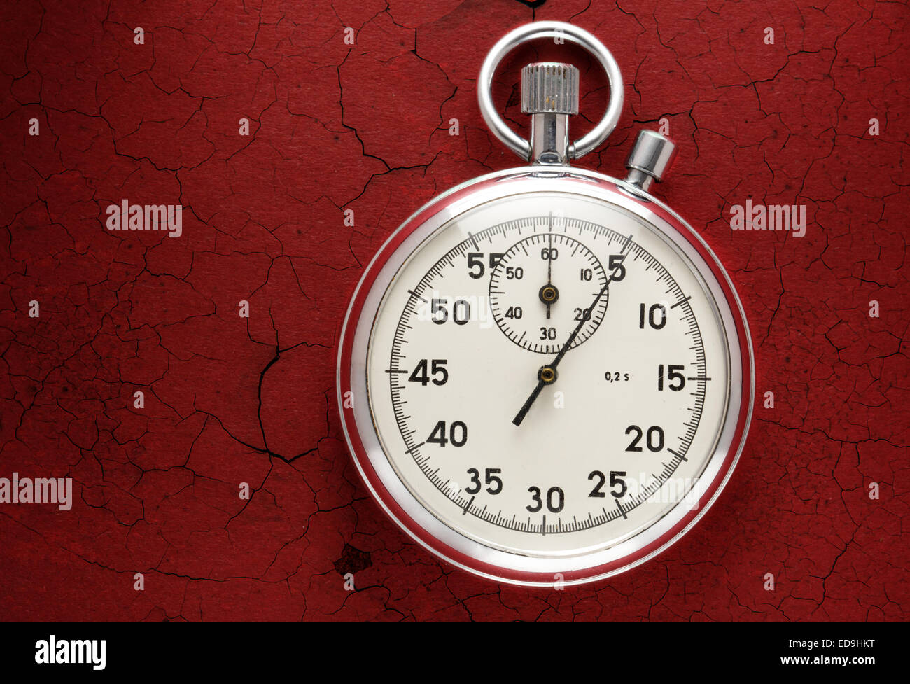 Single stopwatch closeup on red cracked background Stock Photo - Alamy