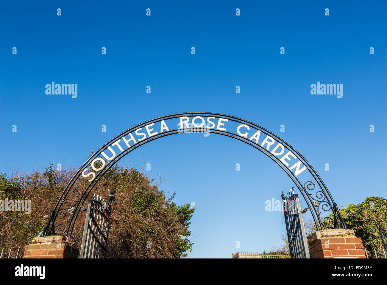 Entrance arch sign at the public Southsea Rose Garden against a blue ...