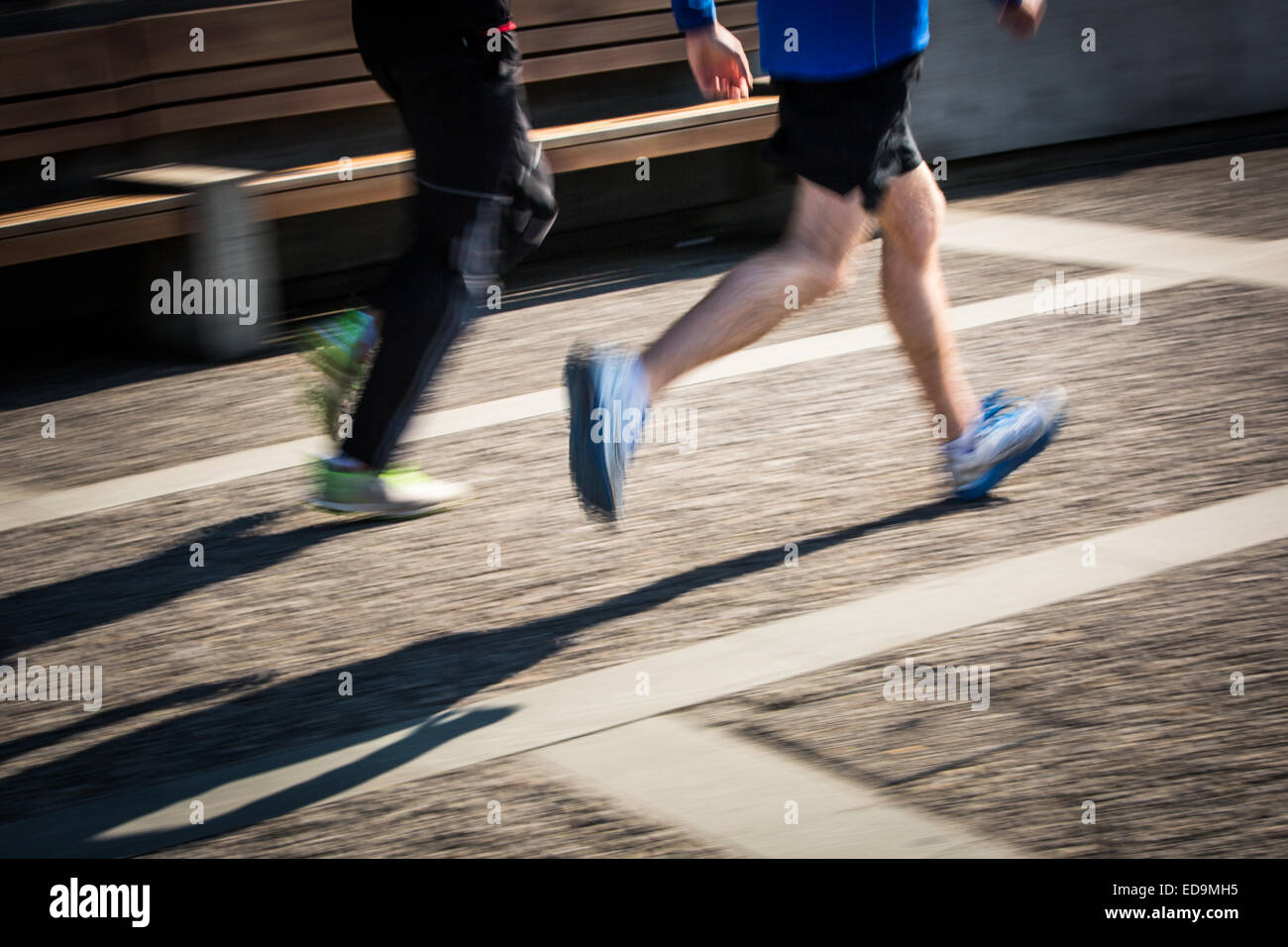Motion blurred runner's feet in a city environment (panning technique ...