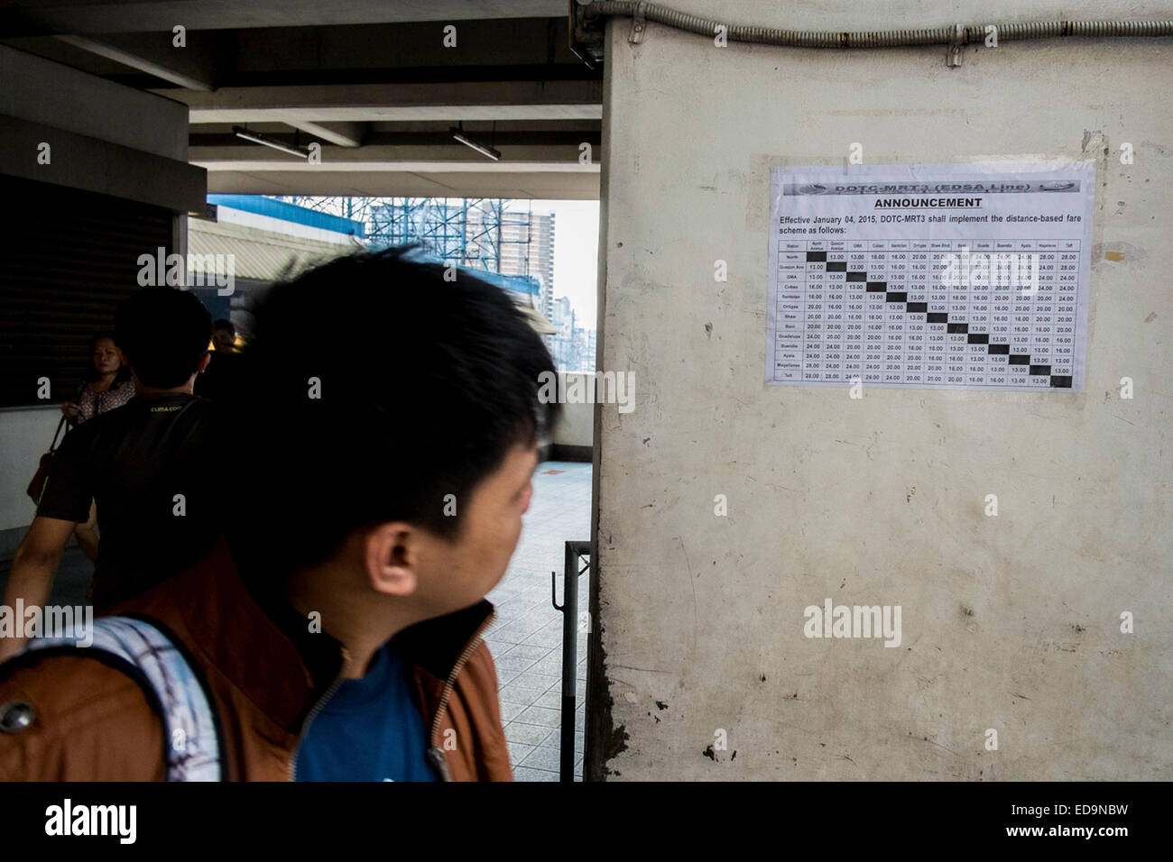 An MRT passenger looks at the new fare matrix that will be implemented ...