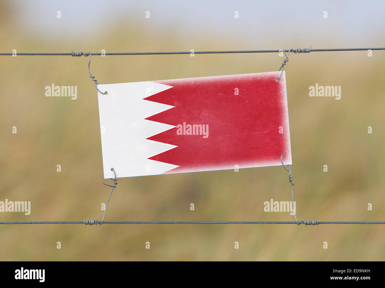 Border fence - Old plastic sign with a flag - Bahrain Stock Photo - Alamy