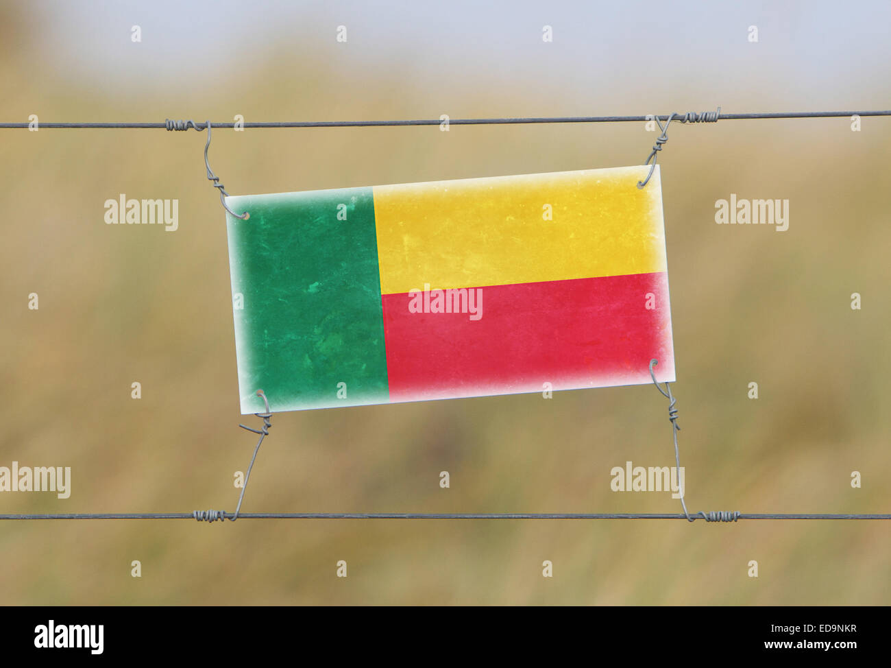 Border fence - Old plastic sign with a flag - Benin Stock Photo - Alamy