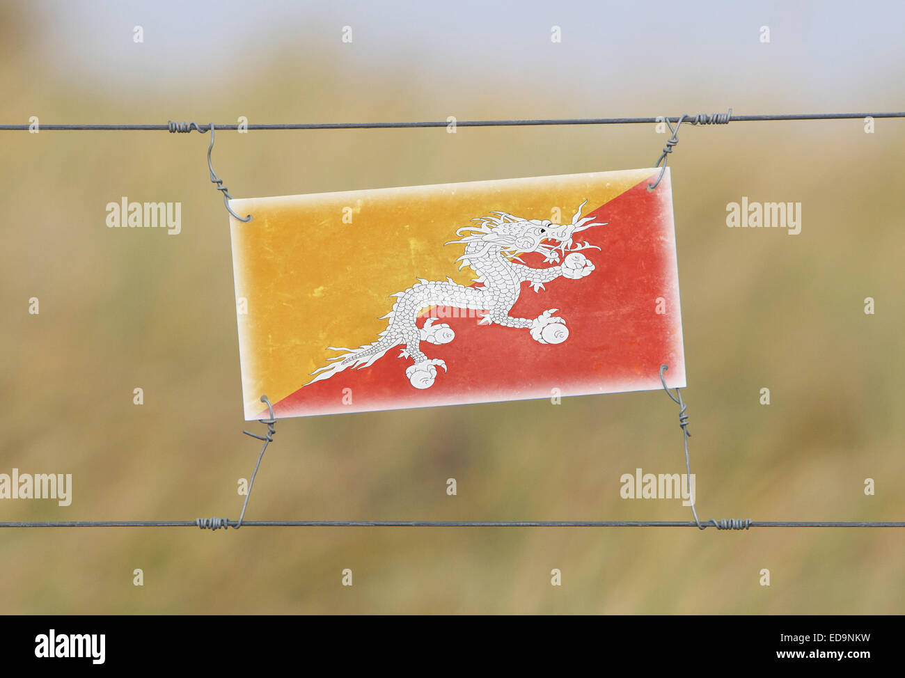 Border fence - Old plastic sign with a flag - Bhutan Stock Photo - Alamy