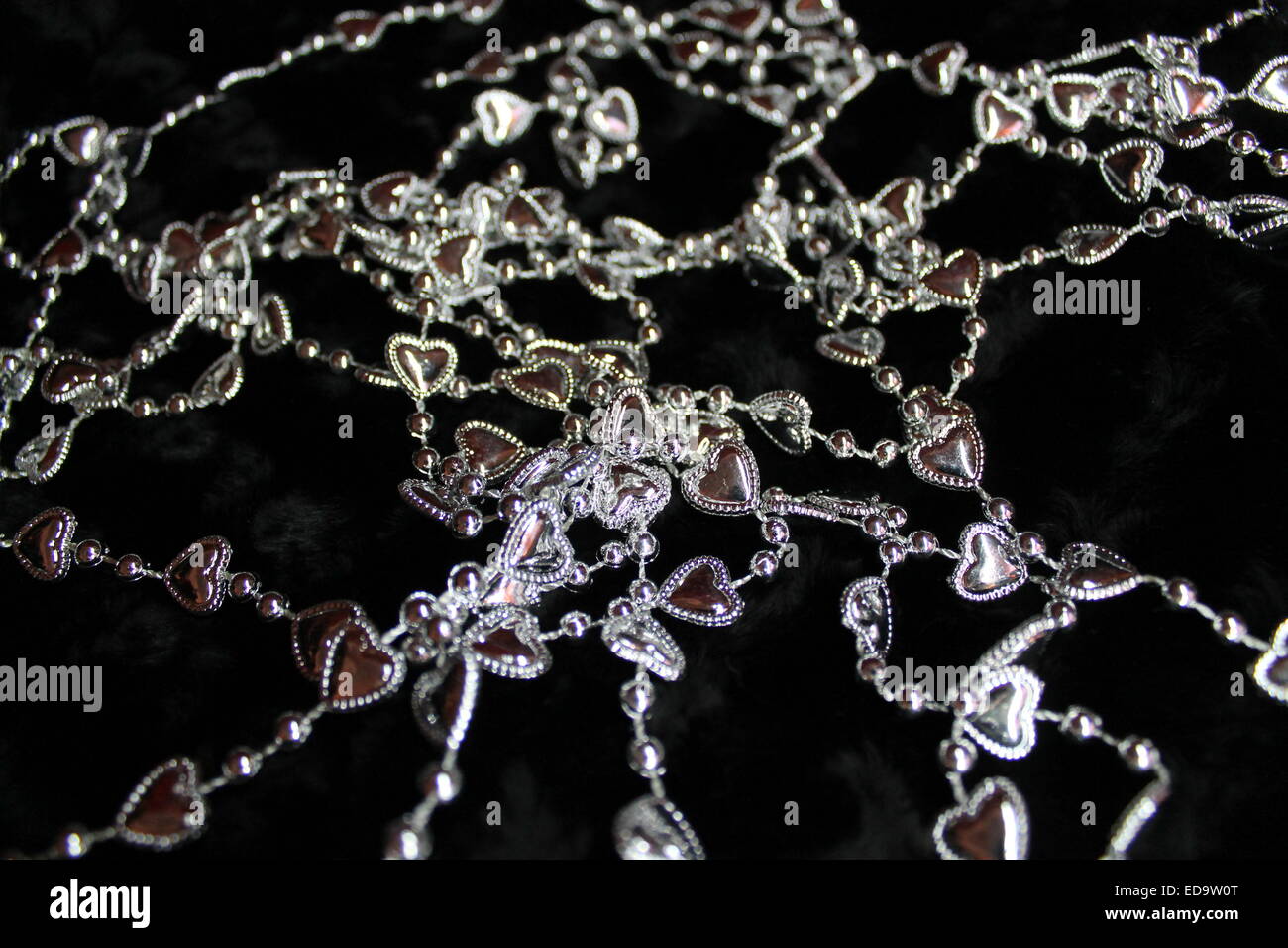 silver shine little hearts on chain lay on black fur Stock Photo - Alamy